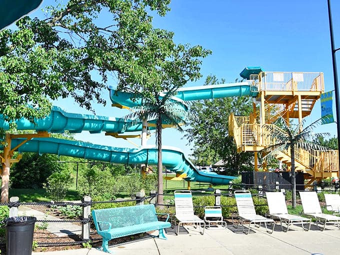 Twisting teal tubes promise moments of gravity-defying delight, supported by a framework of anticipation and wooden stairs.