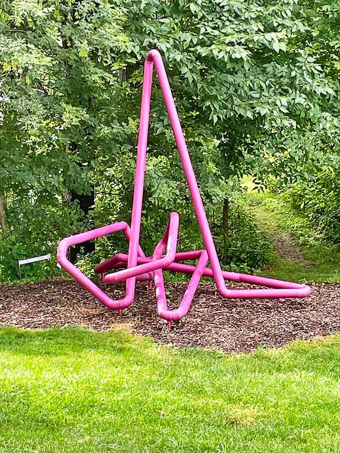 Pink tubular sculpture that looks like someone bent a giant straw into modern art, and honestly, we're here for it.