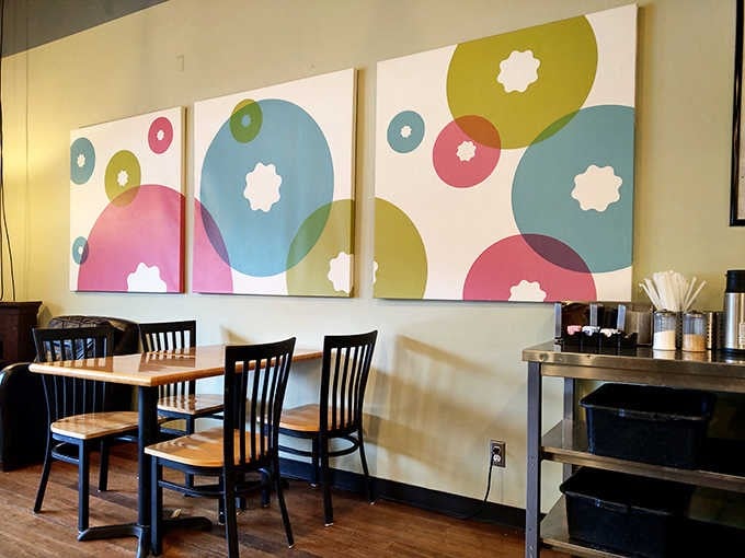 Colorful donut-inspired artwork adorns the walls, creating a playful backdrop for your coffee and pastry experience.