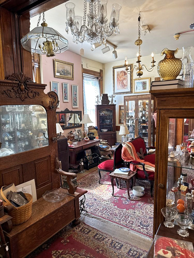 Soft pink walls and crystal chandeliers create an elegant backdrop for antique furniture, transforming this corner into a Victorian parlor fantasy.