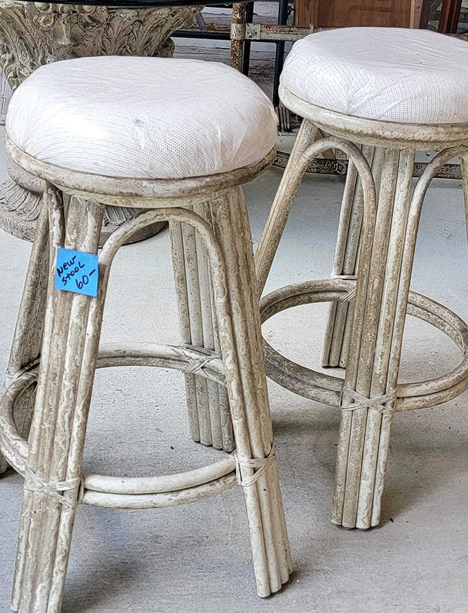 Weathered white bar stools with woven seats invite lingering conversations &ndash; the kind of casual seating that has witnessed decades of Florida stories.
