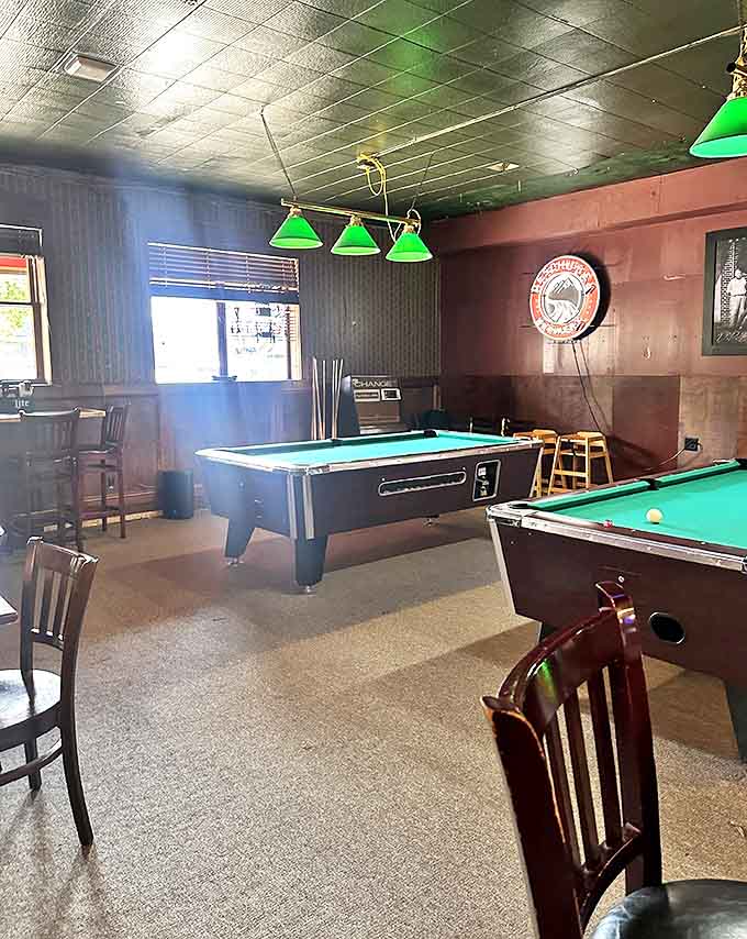 The billiards room waits for challengers under the glow of green-shaded lights, where friendly competition and cold drinks create the perfect evening recipe.