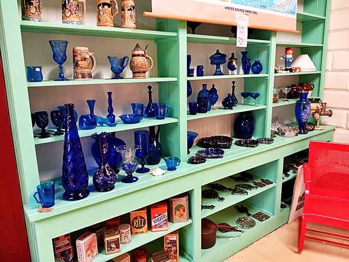 That cobalt blue collection practically sings against mint green shelves, with vintage packaging below that screams mid-century kitchen nostalgia.