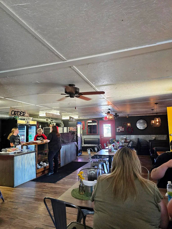 The open dining room buzzes with satisfied customers, while ceiling fans circulate the intoxicating aroma of smoked meats throughout the space.