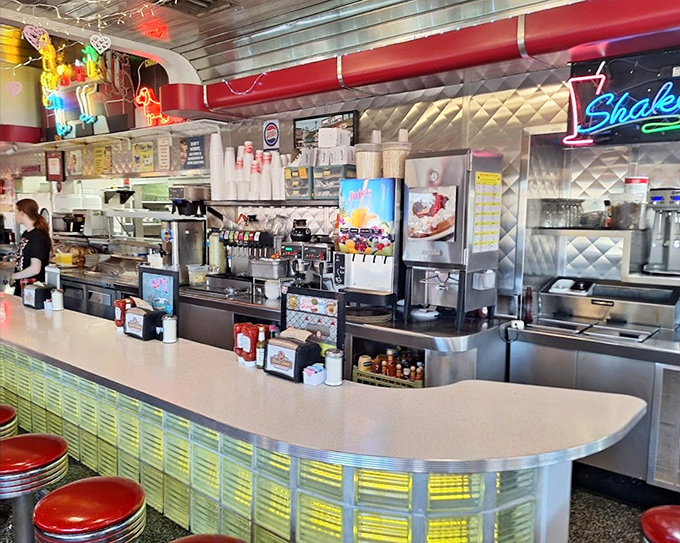 The counter area hums with activity, where milkshakes are born and breakfast dreams come true under the glow of neon.