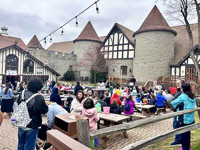 The courtyard comes alive during special events, with families gathering at picnic tables to enjoy community celebrations against the castle backdrop.