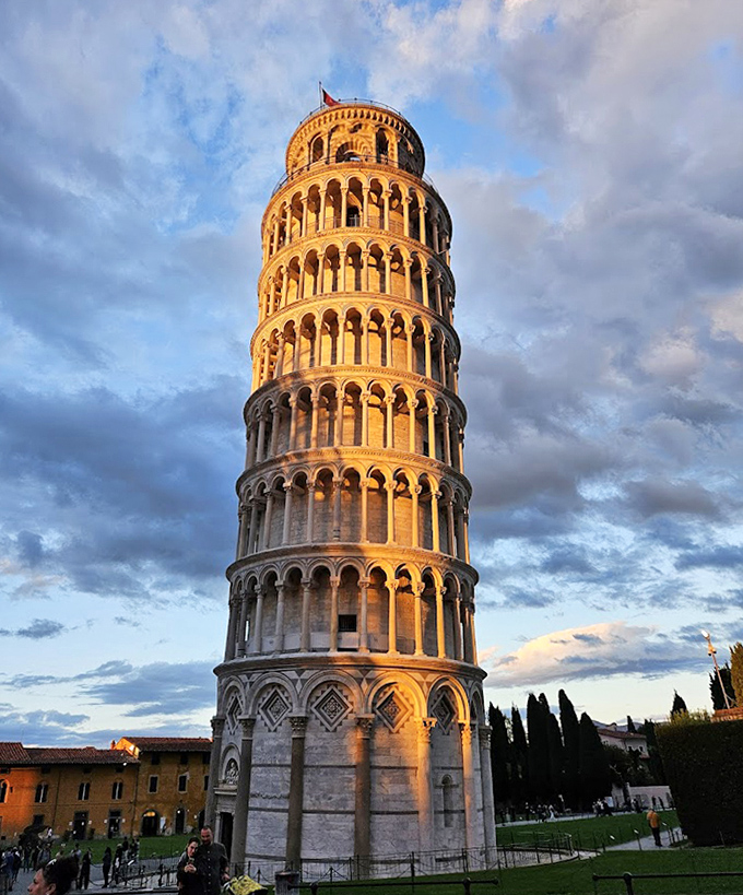 Bathed in sunset light, the tower's white surface takes on golden hues, creating a magical atmosphere as day transitions to evening.
