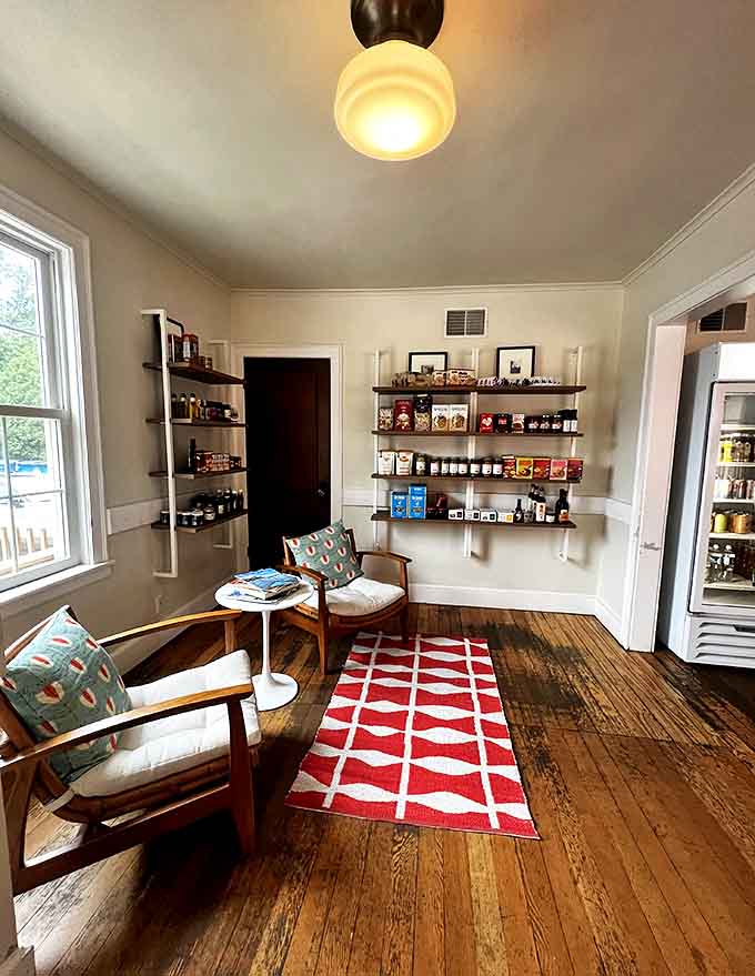 A cozy seating area invites lingering conversations – mid-century modern chairs and wooden floors create the perfect backdrop for coffee-fueled chats.