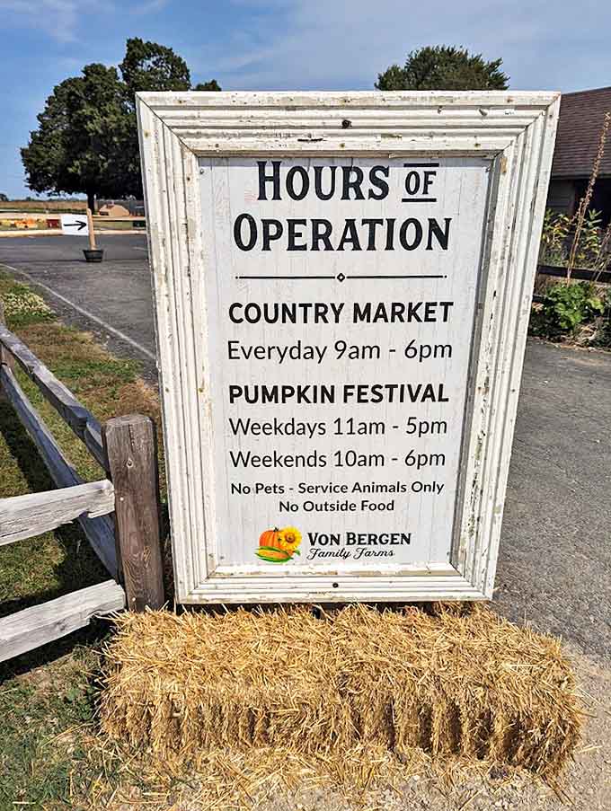 Operating hours posted on a charming framed sign &ndash; because even in paradise, you need to know when to arrive for maximum enjoyment.