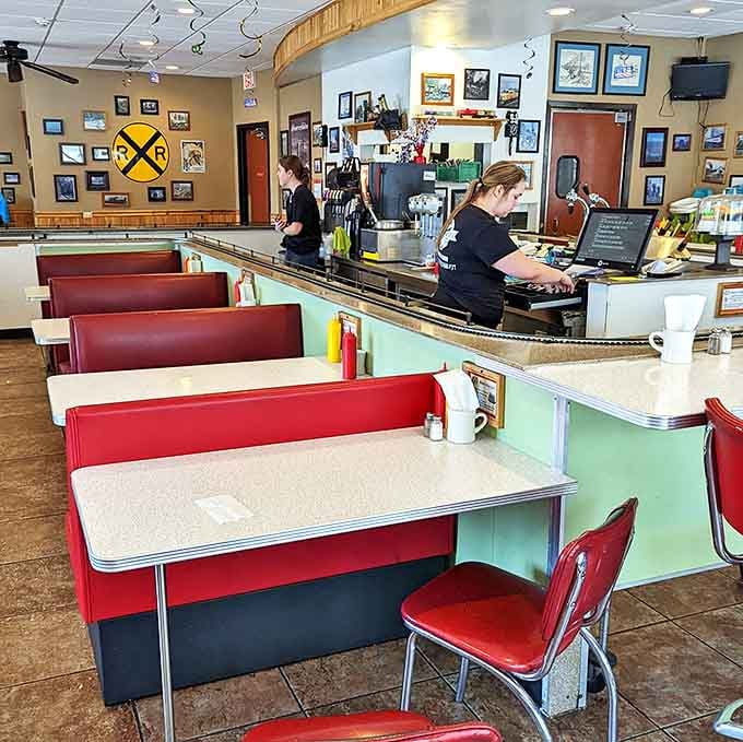 Booth seating positioned perfectly beneath the tracks ensures everyone gets the best view of the culinary train parade happening overhead.