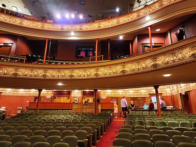 These seats have supported generations of theater-goers, their green upholstery and wooden frames outlasting most modern furniture by about ninety years and counting.