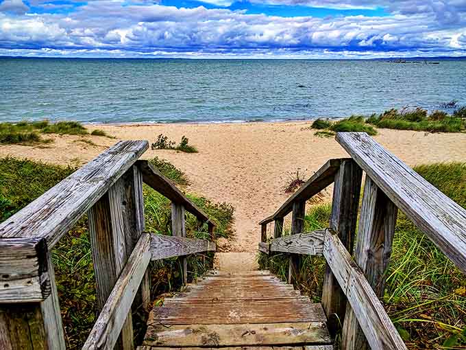 Wooden steps lead down to an undeveloped beach where Lake Michigan's waters lap gently, inviting bare feet and contemplative walks.
