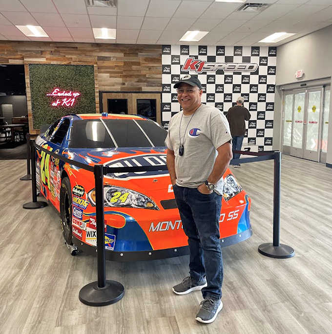 Visitors pose with the display car, mentally comparing their recent lap times to what the pros might achieve on the big track.