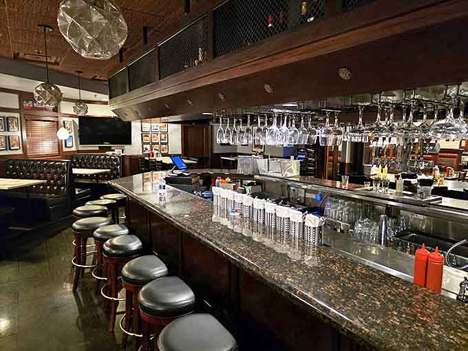 The bar area glows with amber light, bottles gleaming like treasures as bartenders craft cocktails worthy of their devilish surroundings.