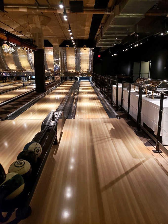 Sleek bowling lanes glow under atmospheric lighting, elevating the humble bowling alley to something approaching glamour.