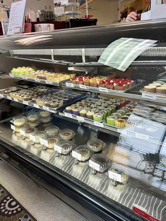 The display case &ndash; where dreams are made and diets go to die &ndash; showcasing rows of meticulously crafted cheesecakes in their full glory.