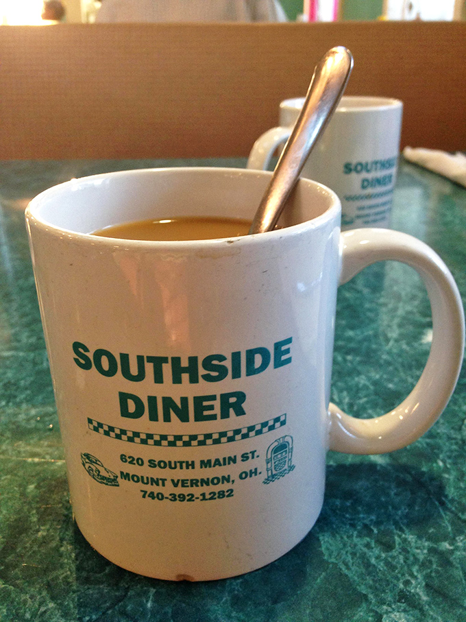 Coffee served in a mug that proudly declares where you are, because even your beverage should celebrate this wonderful discovery.