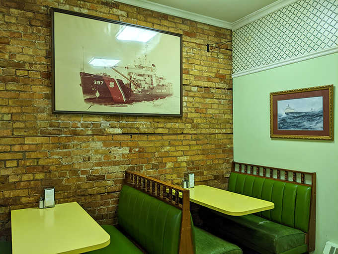 Cozy booth seating against weathered brick walls creates intimate dining nooks where conversations flow as easily as the coffee refills.