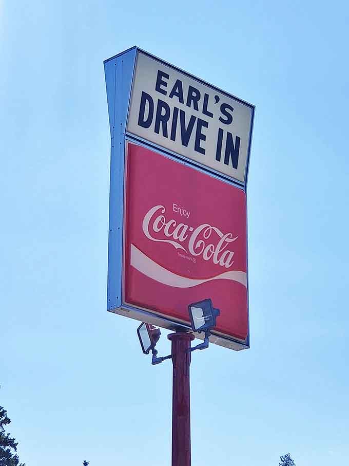 The Earl's Drive-In sign against a perfect blue Minnesota sky – a beacon of hope for those seeking authentic food in an increasingly homogenized world.
