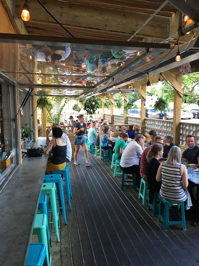 The outdoor patio, with its turquoise stools and string lights, transforms Minnesota evenings into something that feels delightfully far from home.