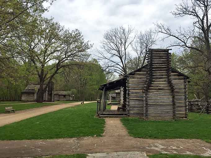 Multiple log cabins demonstrate varying levels of frontier prosperity, from basic survival shelters to relatively comfortable family homes by 1830s standards.