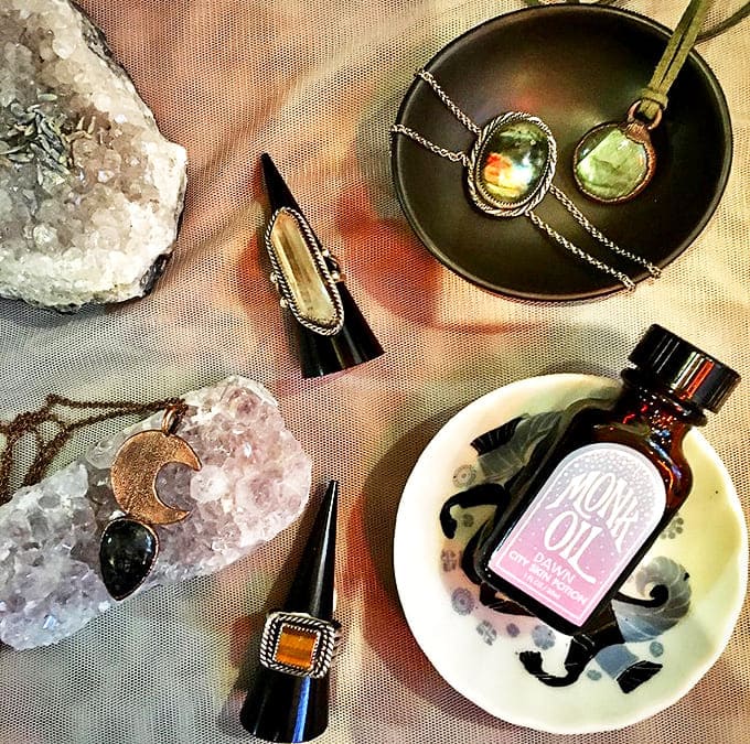 Crystal pendants catch the light beside Love Oil – mystical jewelry and potions promising to enhance both your outfit and your romantic prospects.