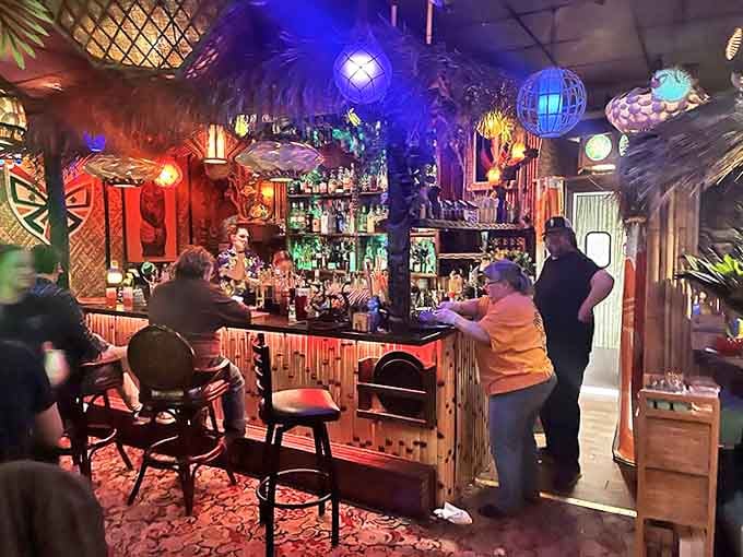 The bamboo-fronted bar is the beating heart of Lola's. Skilled bartenders craft colorful concoctions under the glow of tiki lamps and hanging glass floats.