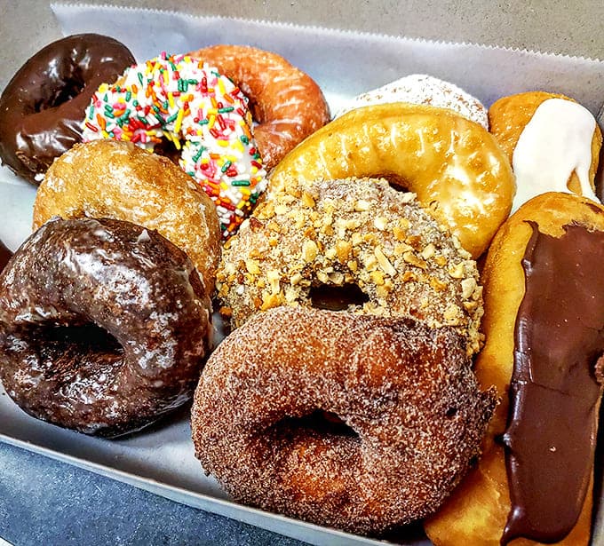 A box of assorted donuts – the adult version of a treasure chest, filled with glazed, sprinkled, and chocolate-dipped gold.