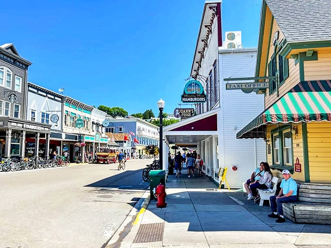 Mackinac Island's Main Street buzzes with activity, its car-free charm creating a delightful throwback to simpler times just a short carriage ride from the Grand Hotel. 
