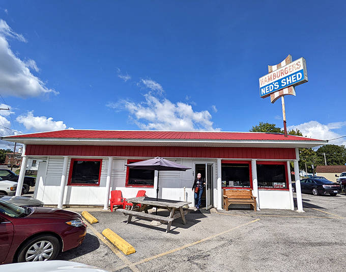 The entrance beckons with no-nonsense charm &ndash; a picnic table, red chairs, and the promise of authentic flavors waiting just beyond that door.