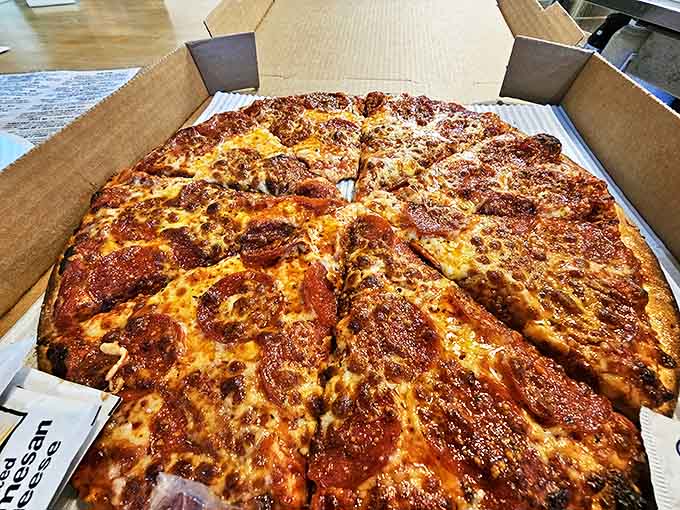 Even in its cardboard chariot, this pepperoni masterpiece maintains its perfect balance of sauce, cheese, and those gloriously crispy-edged pepperoni cups.