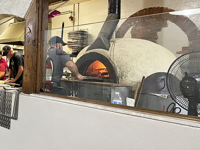 Where the magic begins &ndash; skilled hands working dough while flames dance in the background, promising delicious things to come.