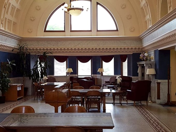 Sunlight streams through arched windows, illuminating the reading room with the kind of natural light that makes pages seem to glow.