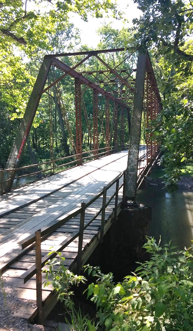 Airtight Bridge spans peacefully over the water in Charleston, Illinois, offering visitors a quiet historic spot surrounded by shady trees and nature.
