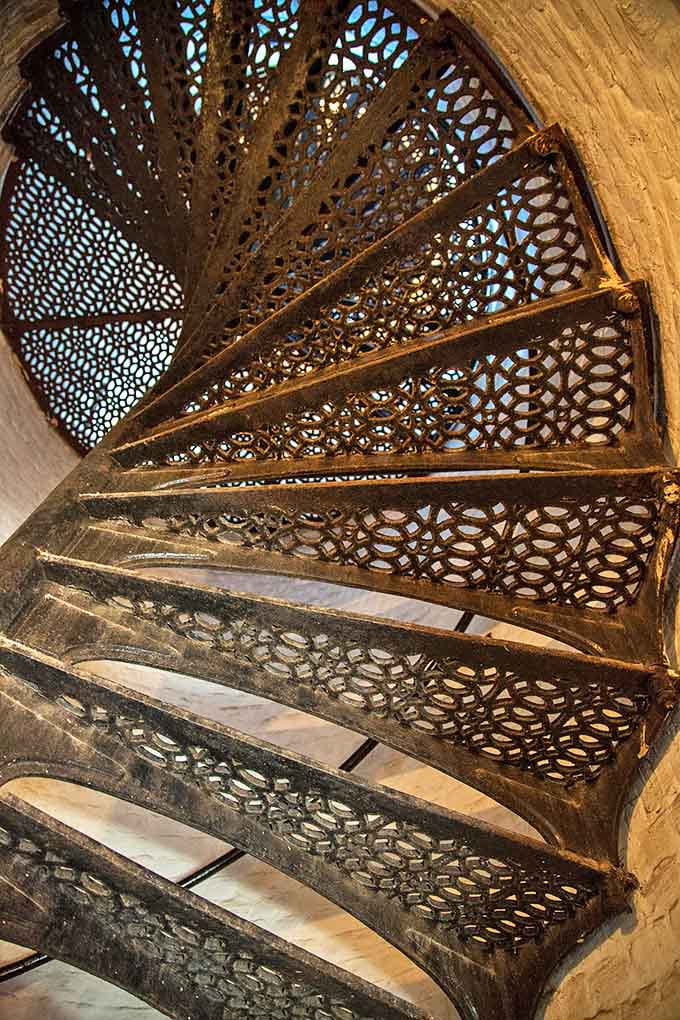 Cast iron steps spiral upward in hypnotic patterns, each worn slightly by 150 years of footsteps climbing toward Lake Michigan's most spectacular viewpoint.