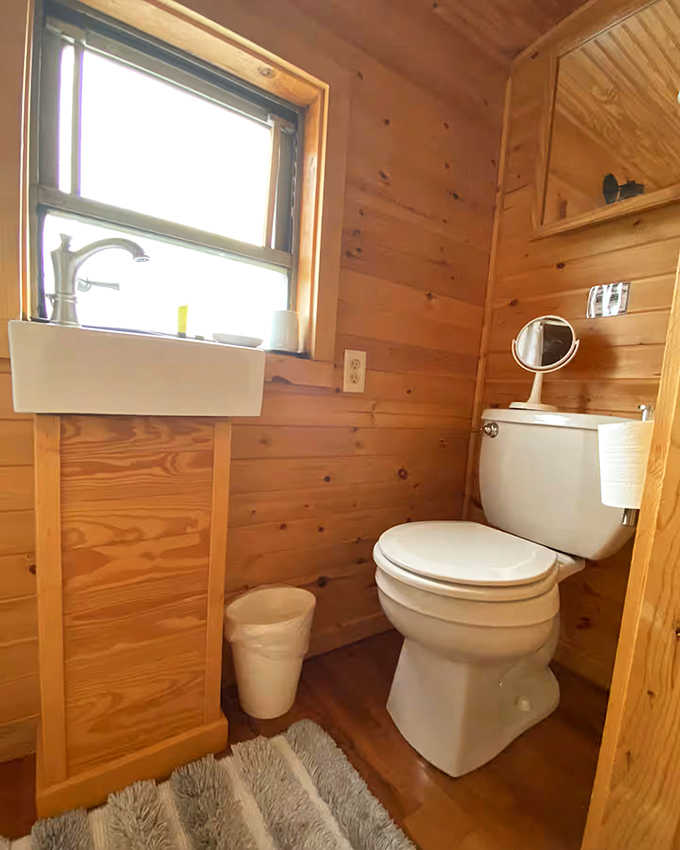 Even the bathroom continues the wood-paneled charm, proving that necessity and whimsy can share the same small space quite happily.
