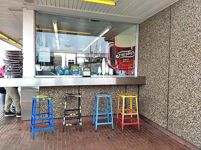 The counter where magic happens &ndash; colorful stools invite you to perch while watching your order materialize through the window.
