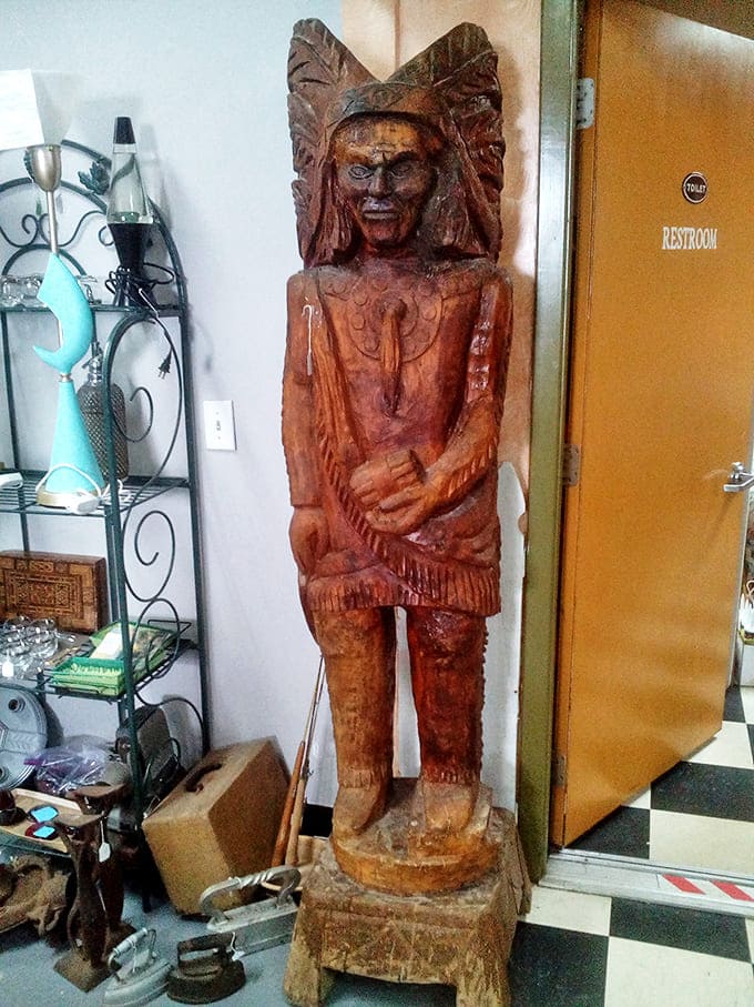 This imposing wooden Native American statue stands sentinel near the restroom, a reminder of America's complicated relationship with indigenous art and representation.