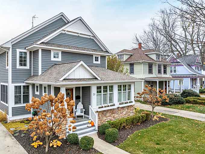 Autumn transforms this residential street into a calendar-worthy scene, where well-maintained homes showcase Michigan's seasonal splendor.