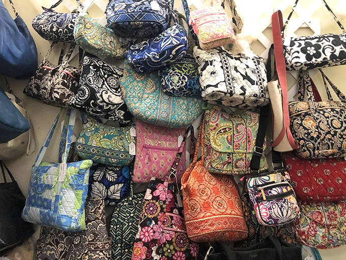 Colorful vintage bags hang like a fabric rainbow, each pattern and style representing a different era when accessories were meant to make a statement, not just hold your stuff.