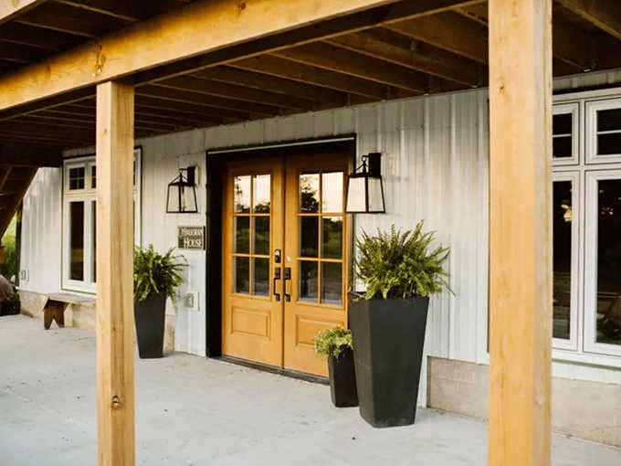 Golden doors flanked by potted greenery create an entrance that says "welcome home" even if you've never been here before.