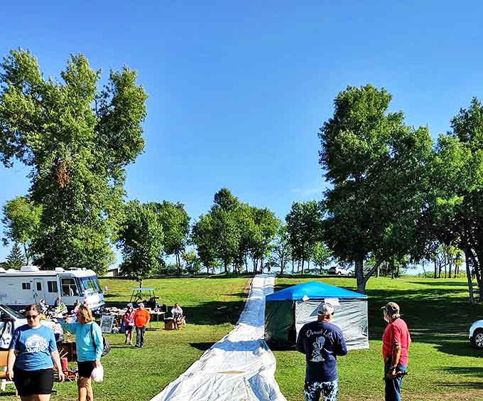 Shoppers stroll between tents under a perfect blue sky, where the promise of undiscovered treasures makes every step an adventure.