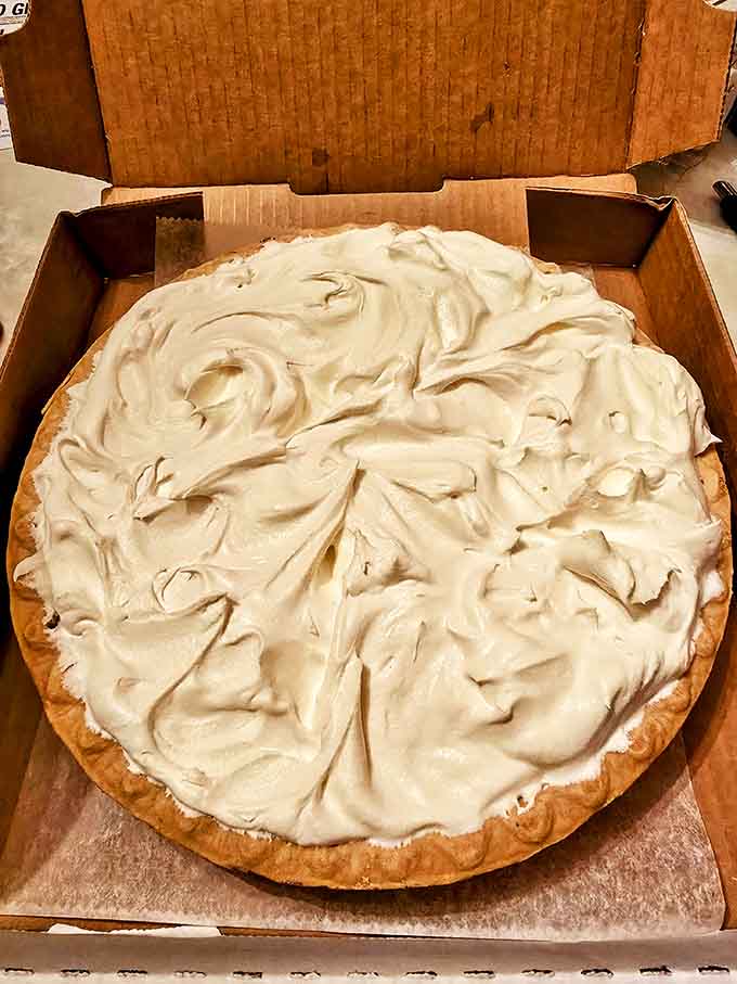 A cream pie topped with billowing meringue sits regally in its box, daring anyone to resist its cloud-like allure.