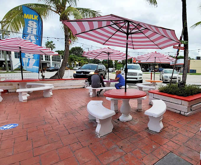 The outdoor patio with its striped umbrellas offers the perfect setting for enjoying frozen treats under swaying palm trees.