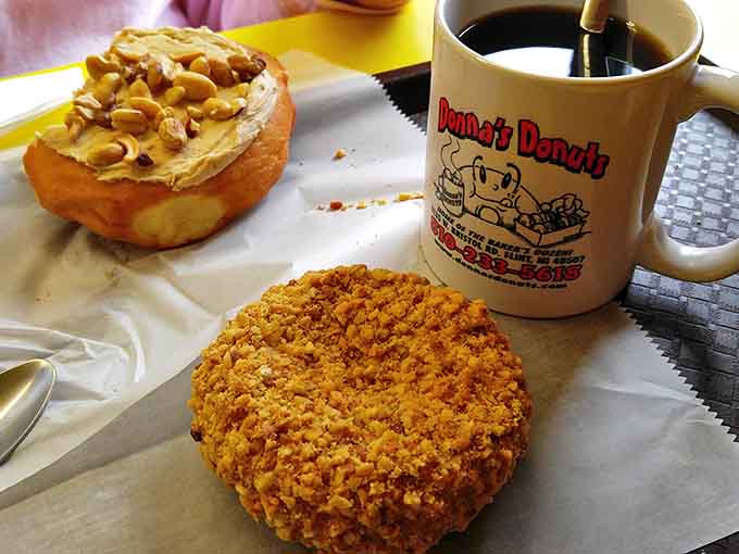 The perfect Michigan morning: a fresh peanut butter donut, a crunchy-topped masterpiece, and Donna's signature coffee in their iconic mug.