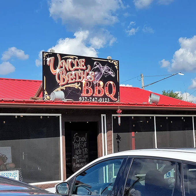 The sign beckons from the roadside like a smoky siren call, promising delicious things to those wise enough to stop.