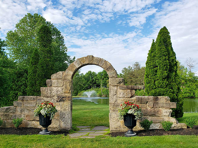 Ancient-looking stonework frames a perfect view of fountain-adorned waters beyond—a portal between everyday life and vineyard enchantment.