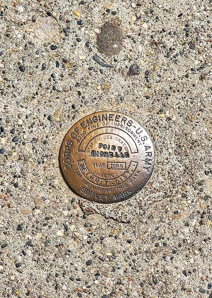 This survey marker tells you you're standing at an officially important spot, where engineers once measured and planned to keep ships and sailors safe.