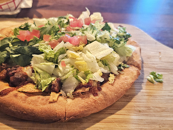 Taco pizza: Culinary fusion at its finest&mdash;a personal pizza that marries the best of Mexican flavors with Italian tradition, topped with fresh lettuce and tomato.