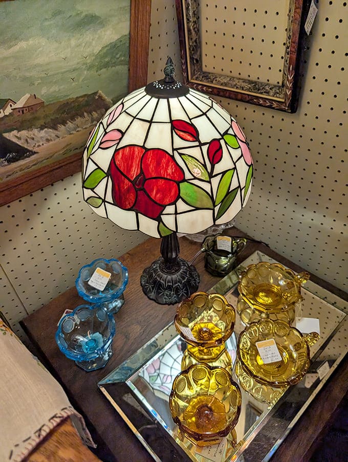 This Tiffany-style lamp casts a warm glow over colorful Depression glass &ndash; the kind of lighting that makes everything look more romantic, even old ashtrays.
